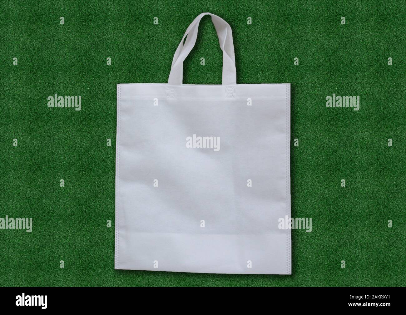 White fabric cloth Recyclable ECO Bag on Green Grass background ...
