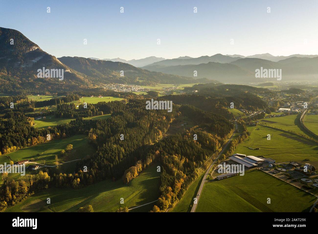 Aerial view of green meadows with villages and forest in austrian Alps ...