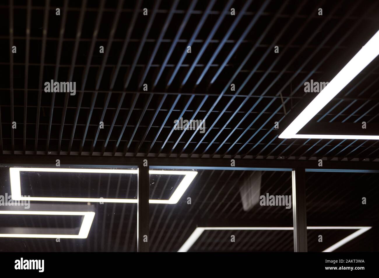 Modern office lighting. Thin lamps in office dark ceiling. LED white ...