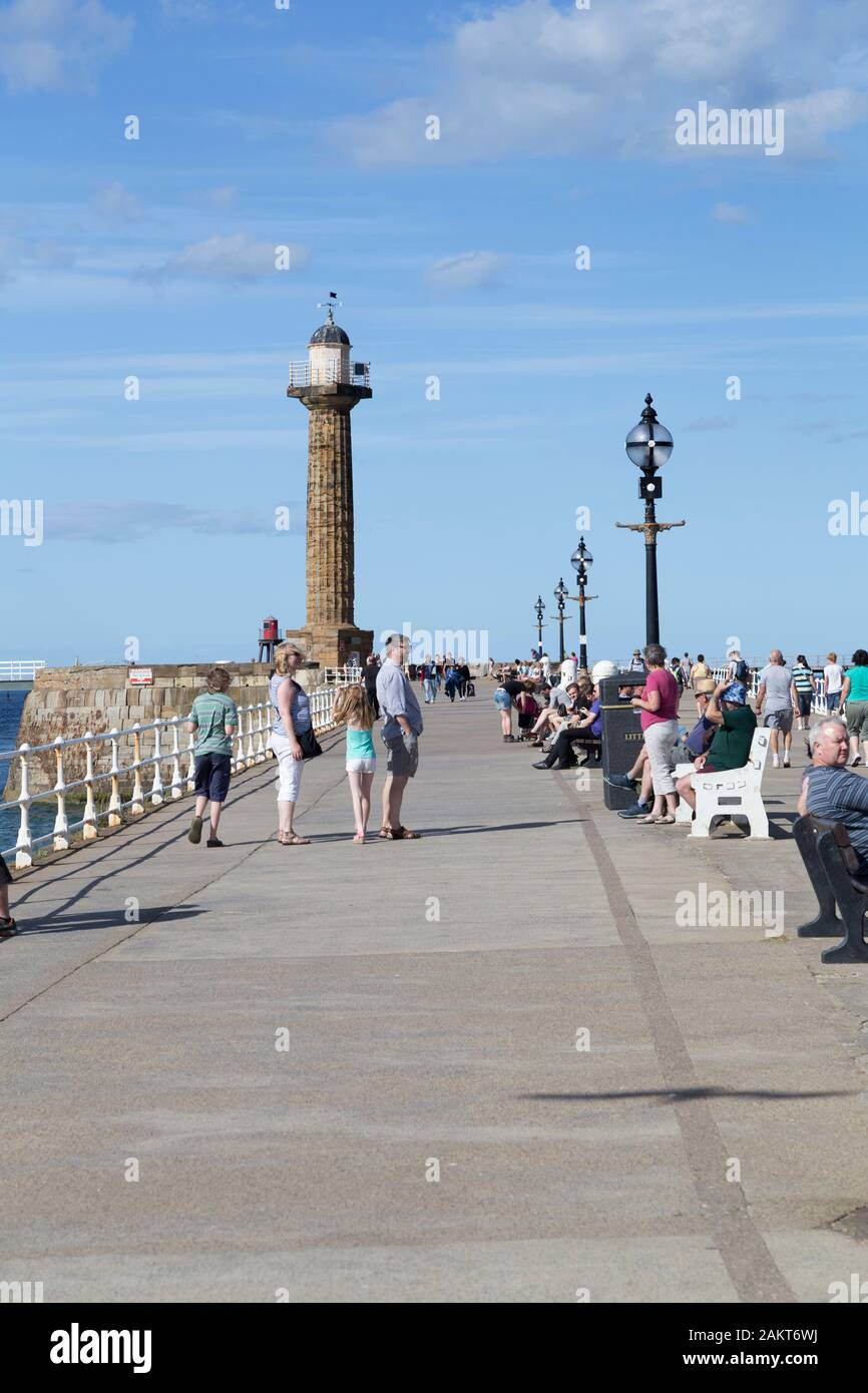 People on the WHitby West side harbour wall and lighthouse Stock Photo ...