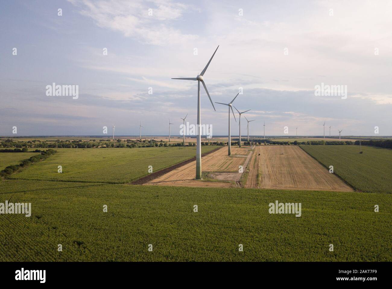 Aerial view of wind turbine generators in field producing clean ...