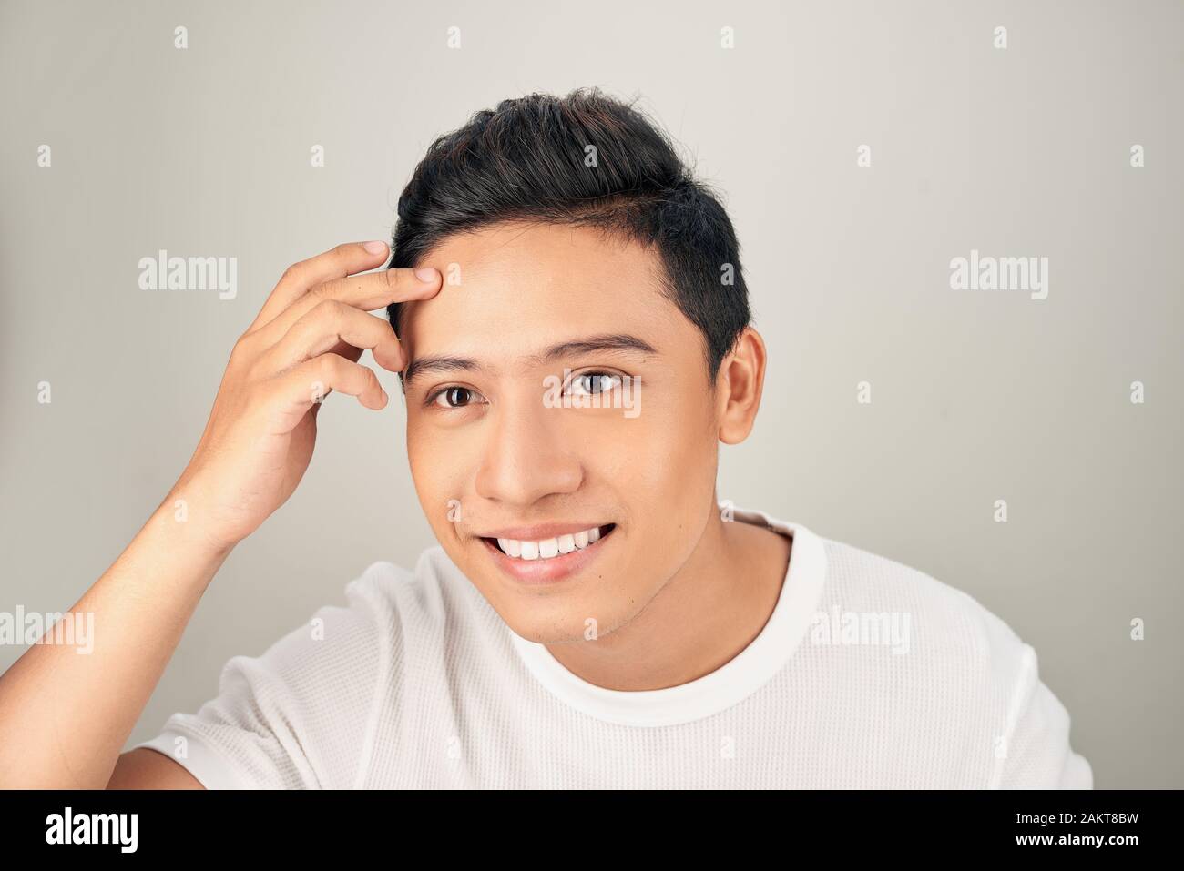 Handsome man touching his face close up portrait studio on white ...