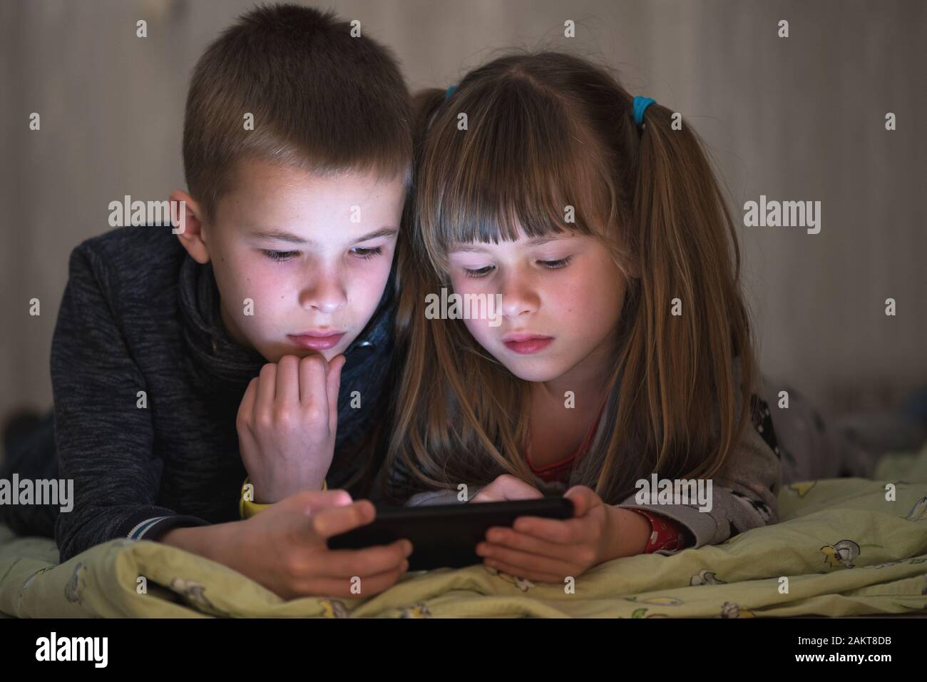 Two children brother and sister watching video on smartphone screen ...