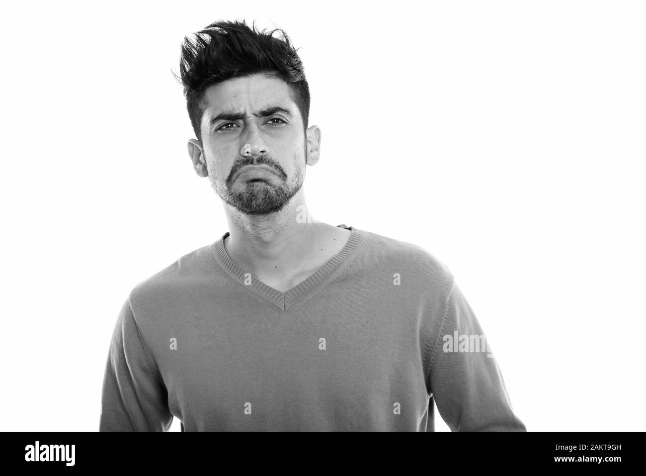 Studio shot of young Persian man looking sad Stock Photo - Alamy