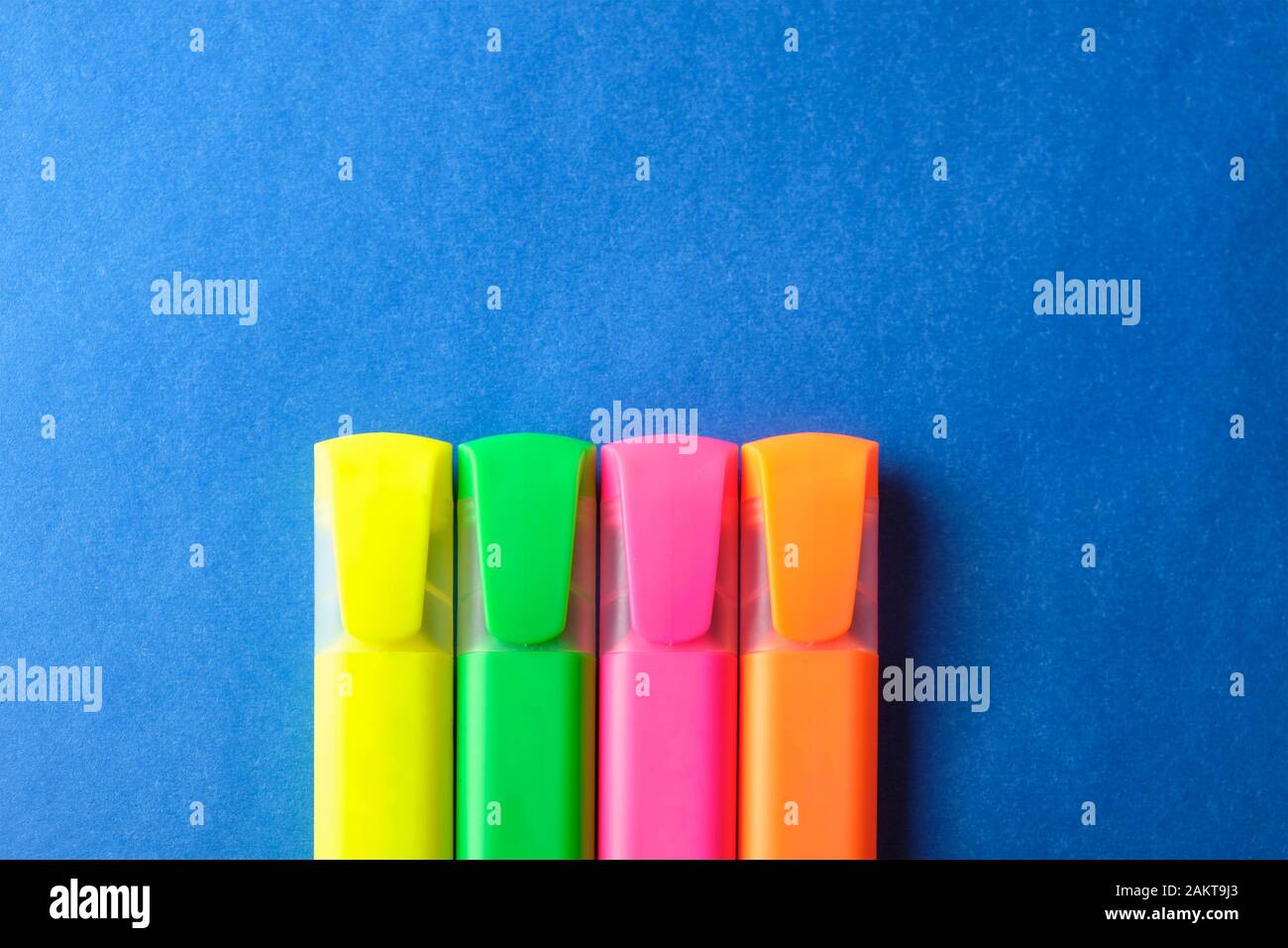 Multi colored highlighters at blue background with copy space Stock ...