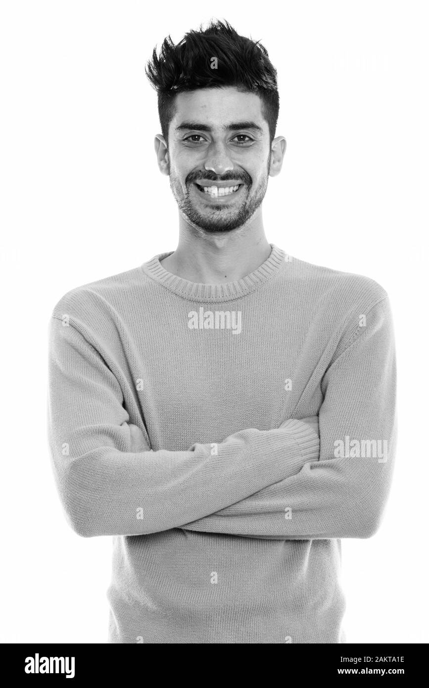Studio shot of young happy Persian man smiling with arms crossed Stock ...