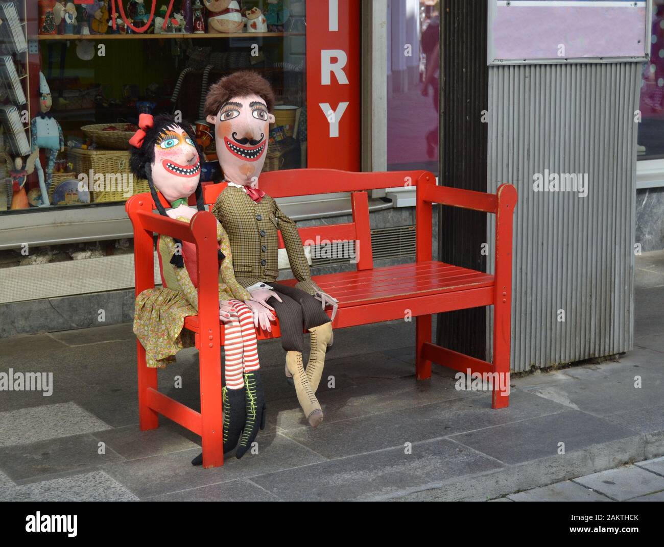 Puppet couple imitating a married couple sitting on a bench in the ...