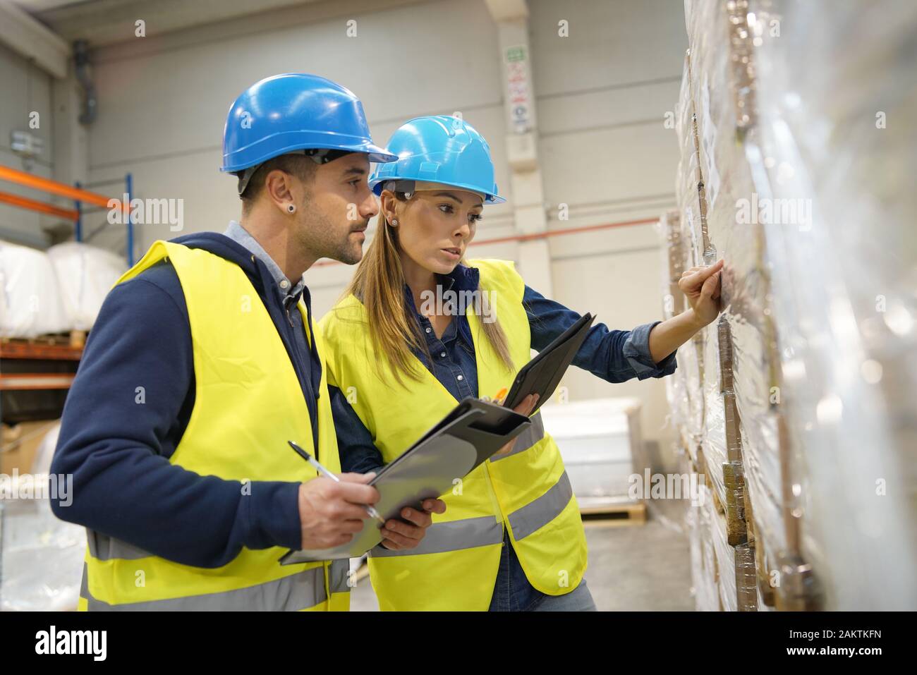 Workers in warehouse controlling incoming merchandise Stock Photo - Alamy