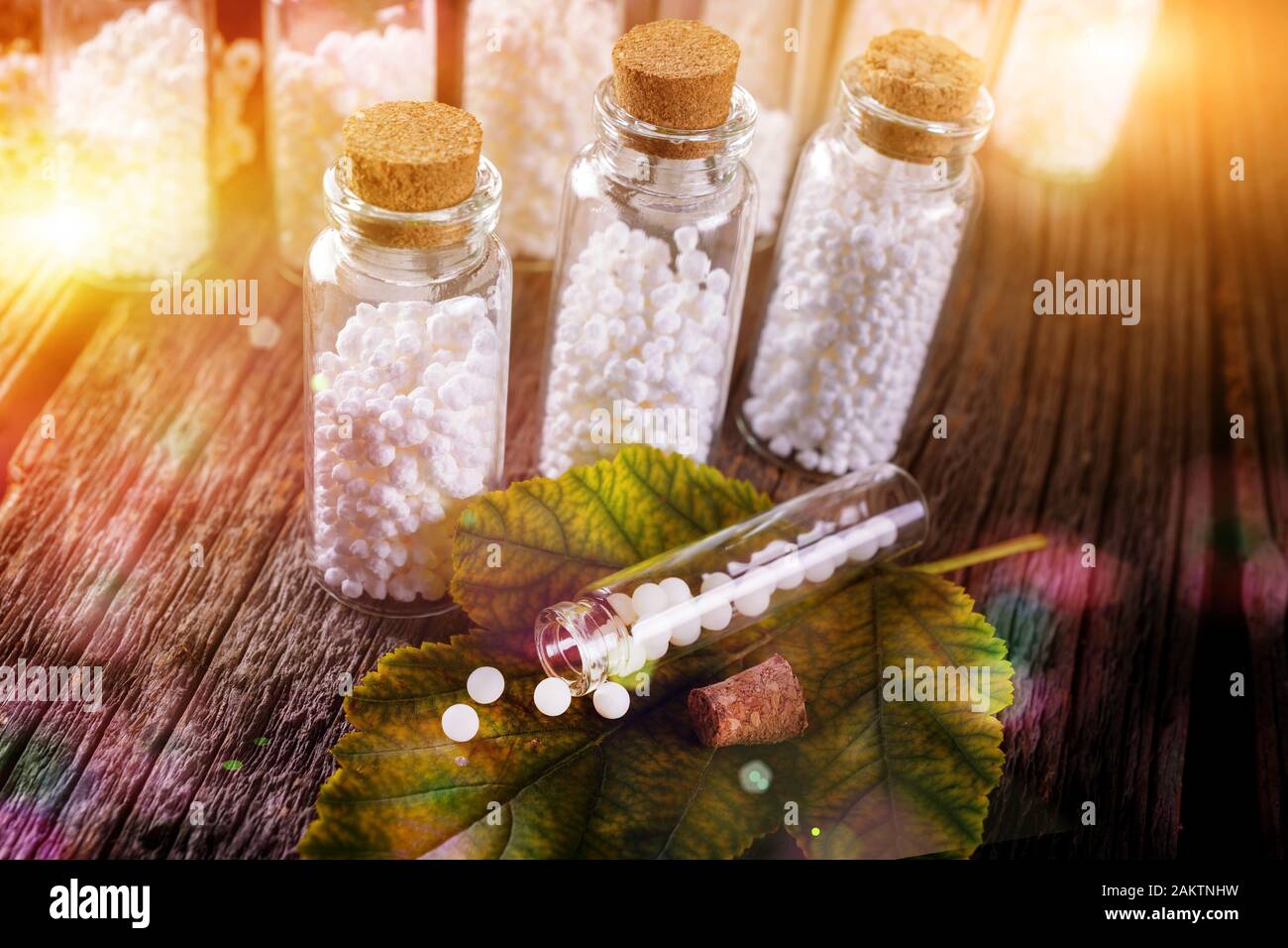 Homeopathic lactose sugar globules on leaf with glass bottle Stock ...