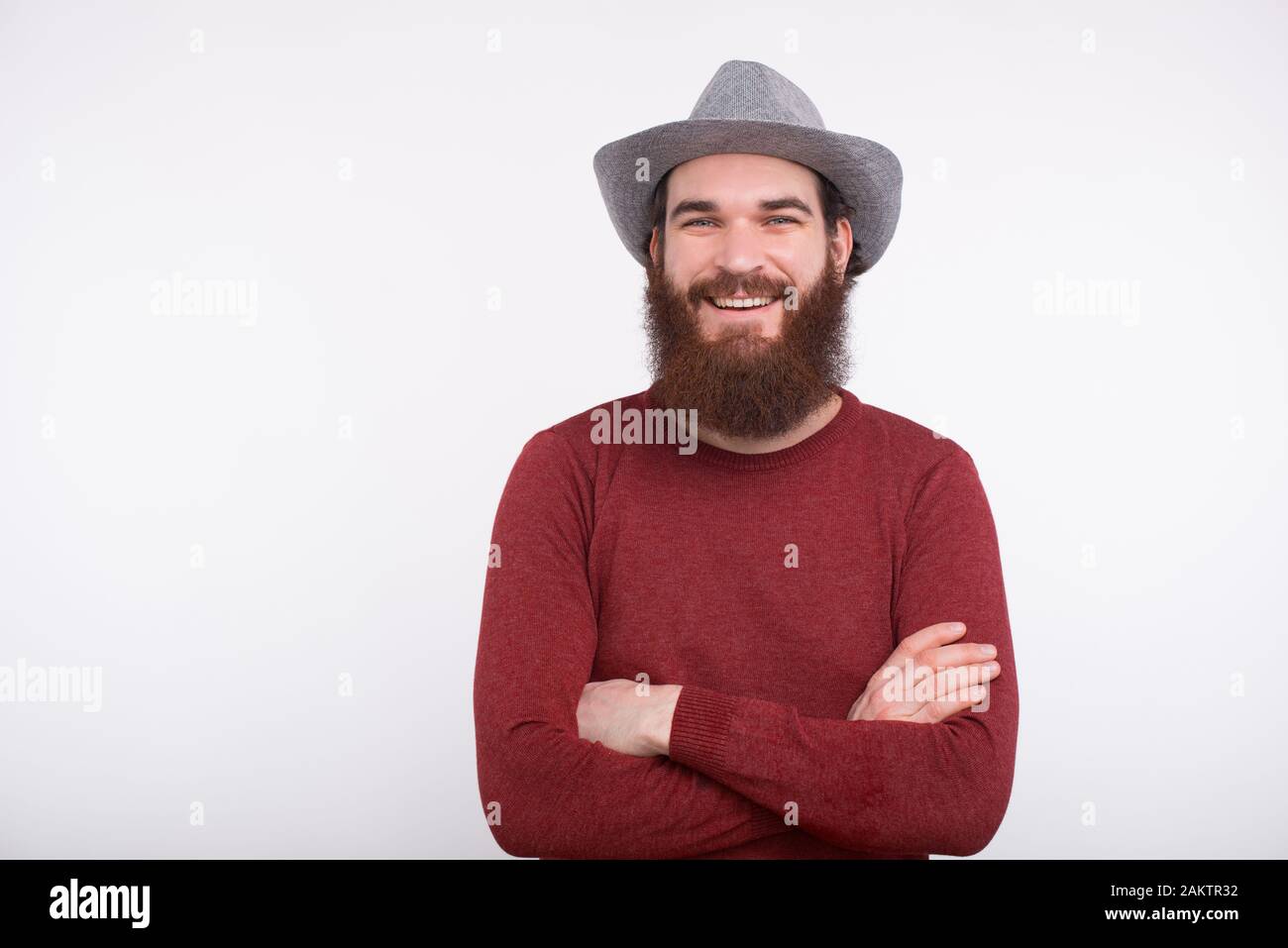 Portrait of happy bearded man with crossed arms lookit at the camera ...