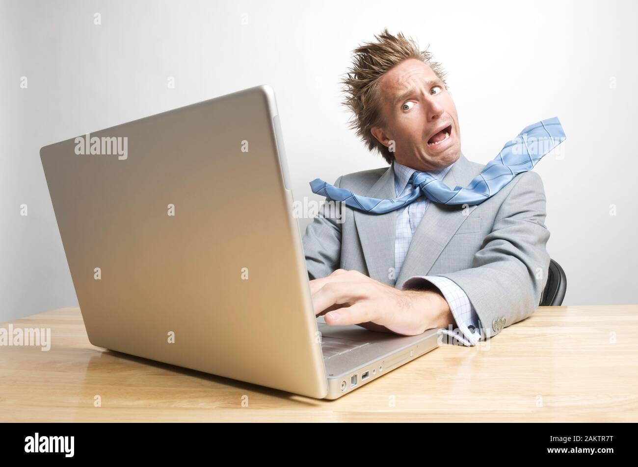 Shocked businessman opening a file on his laptop computer full of bad ...