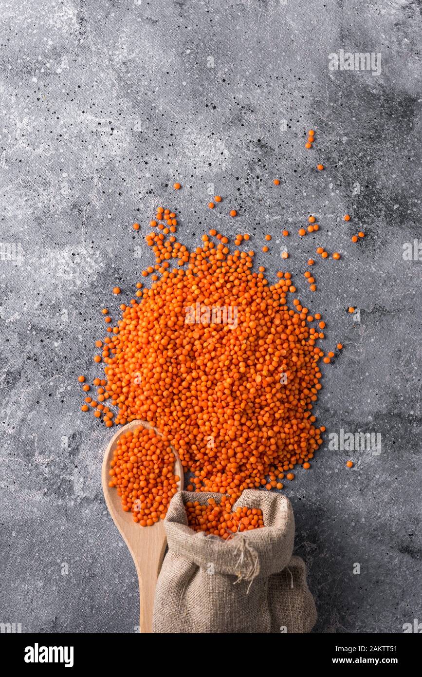 lentils on a gray background red lentils in a wooden spoon and bag ...