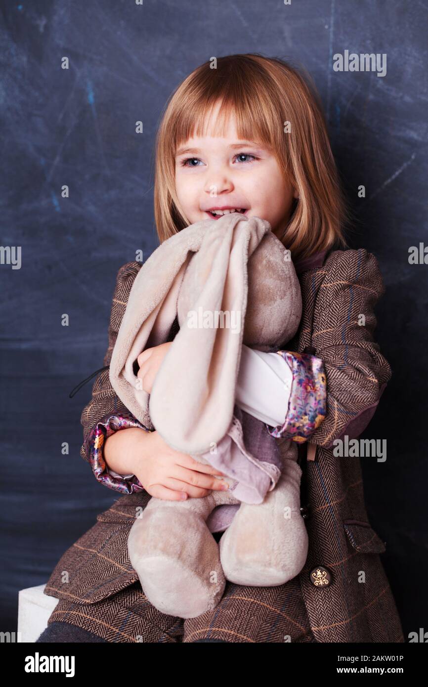 Cute Happy little girl hugging her toy rabbit Stock Photo - Alamy