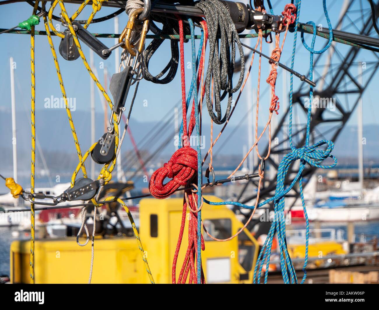 ropes and sailing lines hang down from a boat mast. The multicolored ...