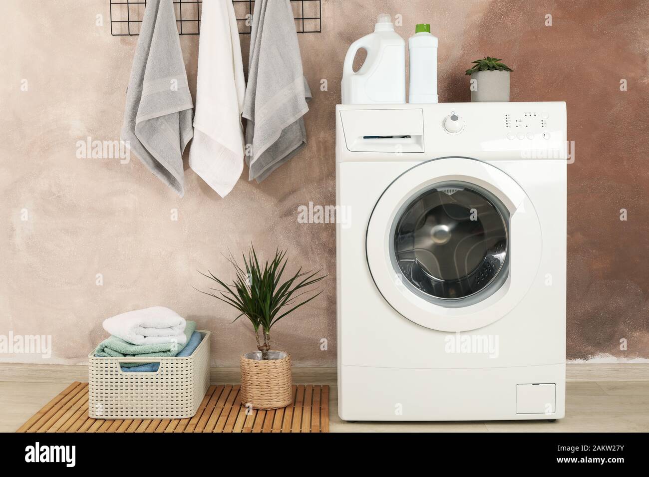 Laundry room with washing machine against brown wall Stock Photo - Alamy