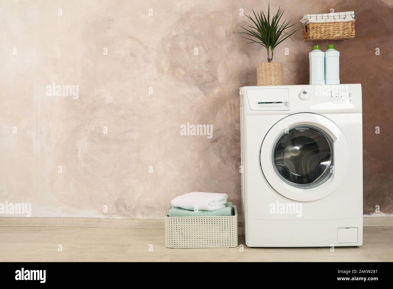 Laundry room with washing machine against brown wall Stock Photo - Alamy