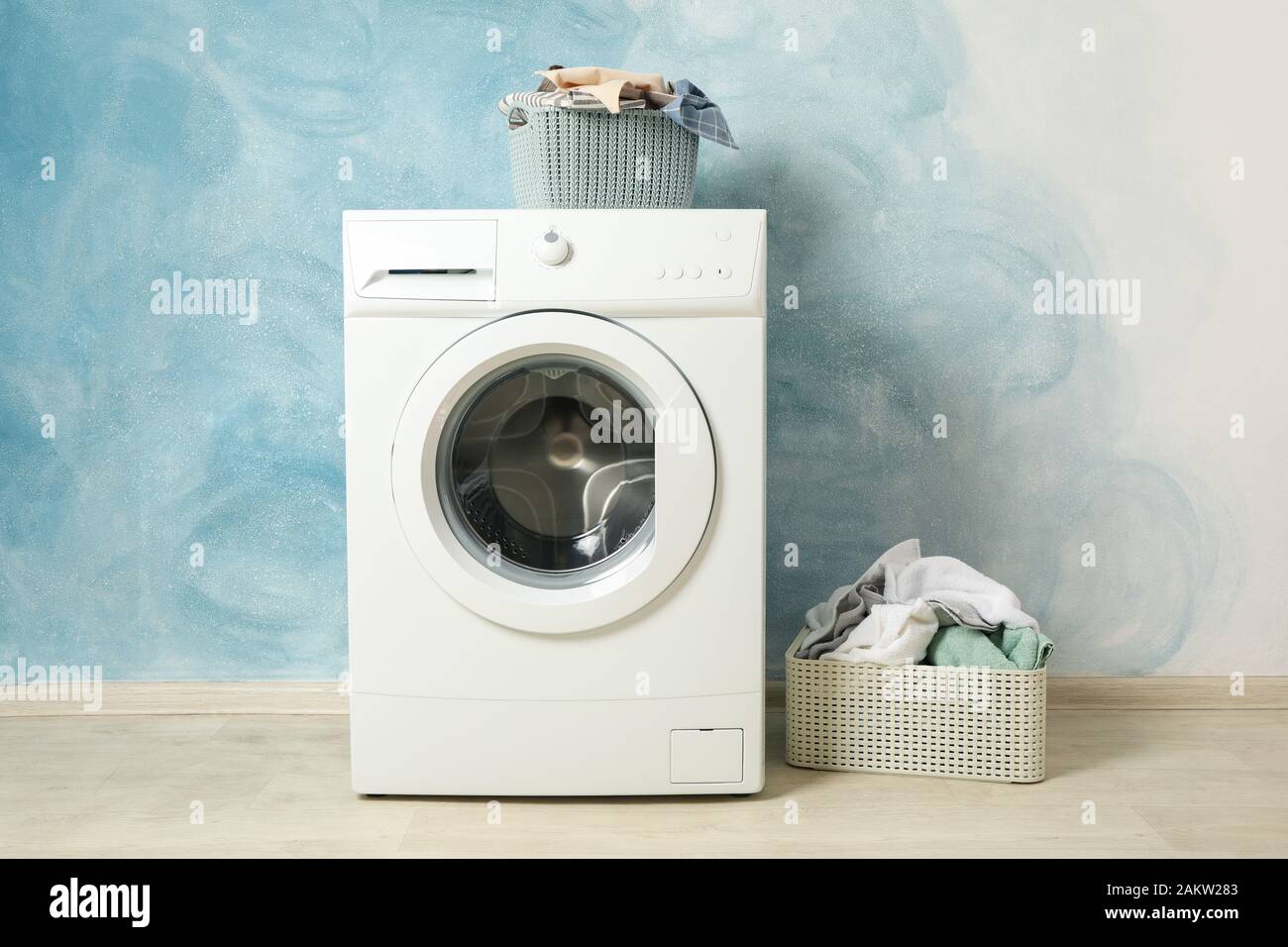 Laundry room with washing machine against blue wall Stock Photo - Alamy