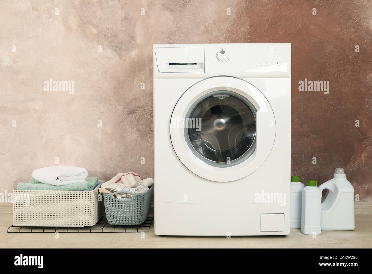 Laundry room with washing machine against brown wall Stock Photo - Alamy