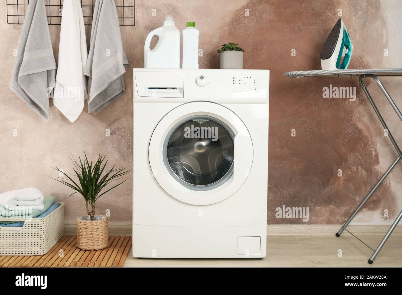 Laundry room with washing machine against brown wall Stock Photo - Alamy