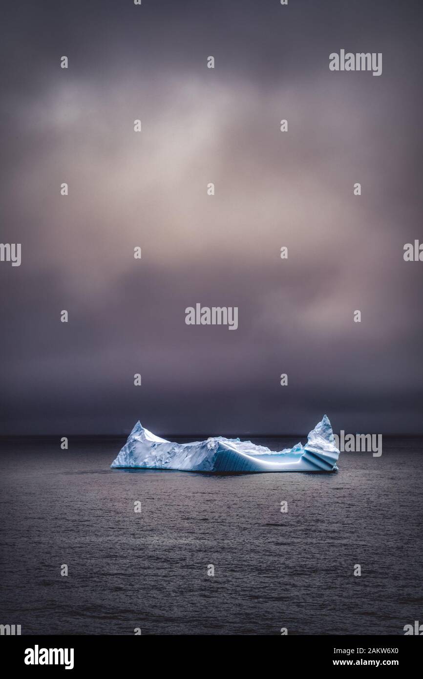 Dramatic image of a single iceberg with sharp spiky edges floating in ...