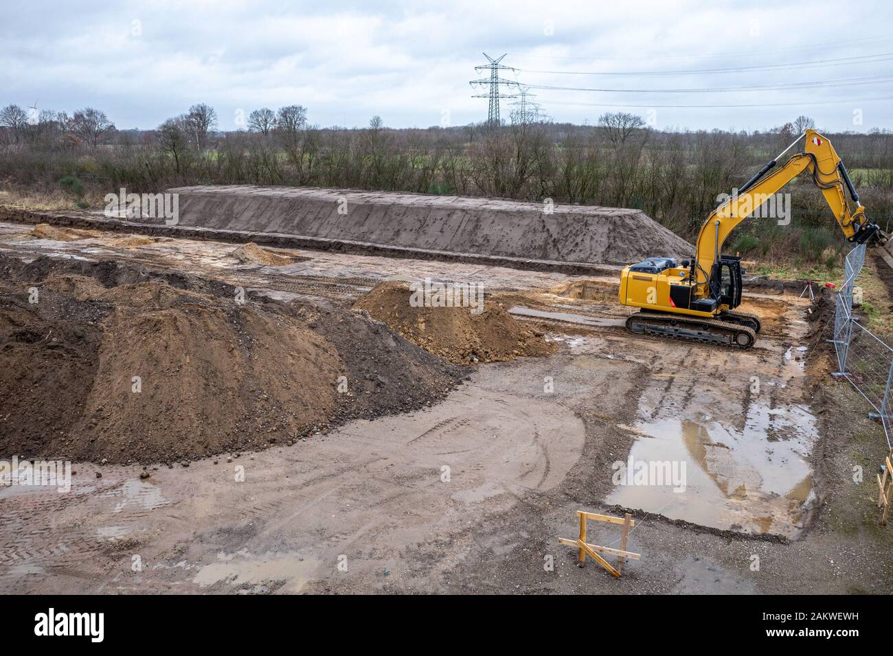 on a large construction site, excavators are used to remove topsoil so ...