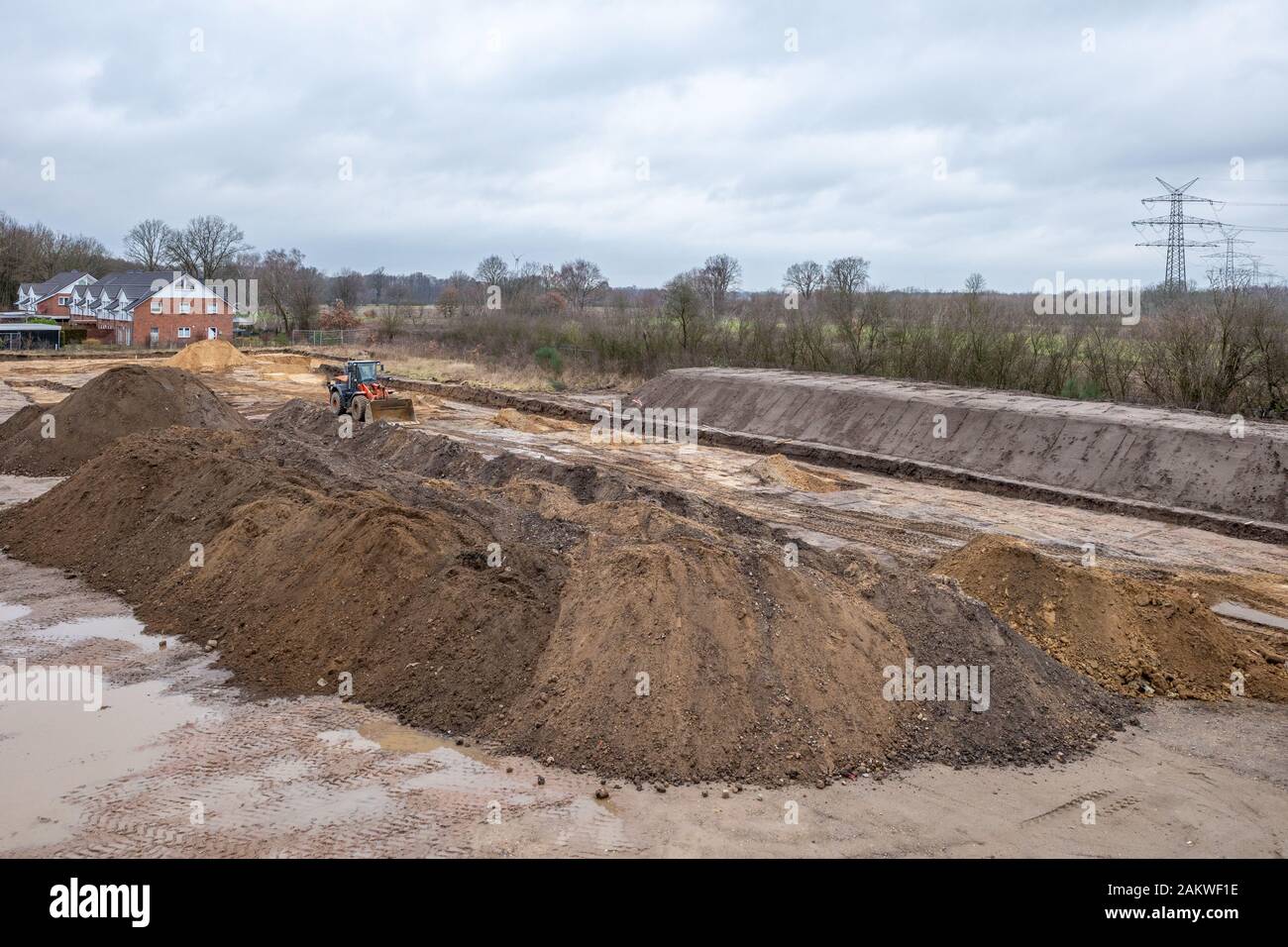 on a large construction site, excavators are used to remove topsoil so ...