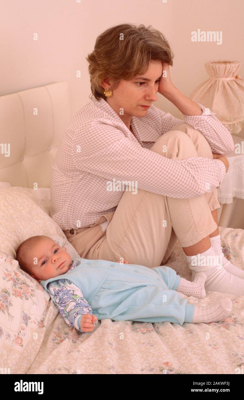 young mother with a baby suffering from post natal depression, looking ...