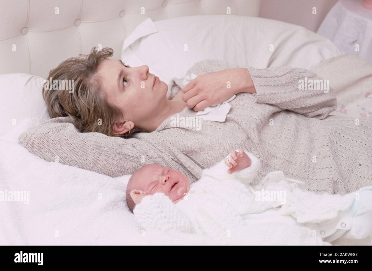 young mother with a baby suffering from post natal depression, looking ...