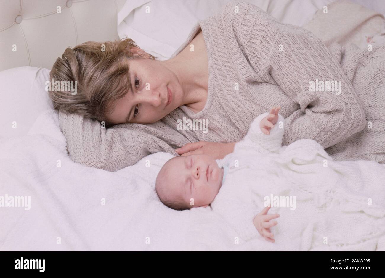 young mother with a baby suffering from post natal depression, looking ...