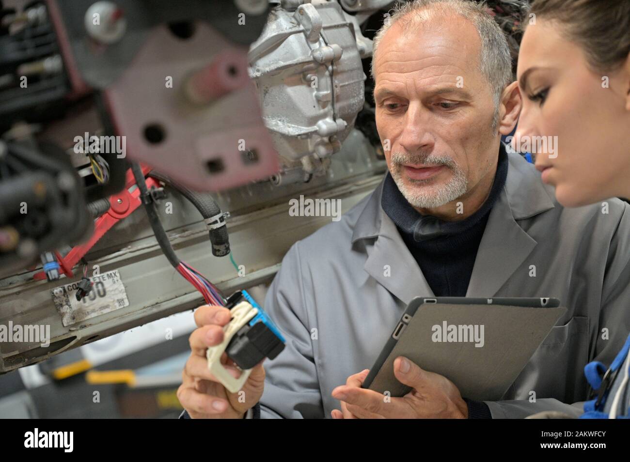Trainee with mechanics manager working on car technology Stock Photo ...