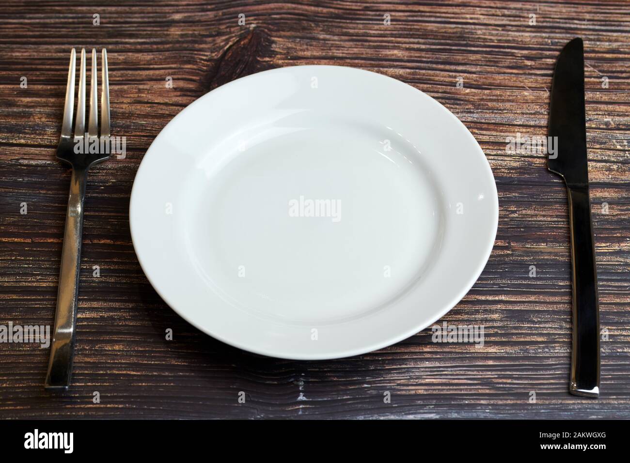 Empty plate on table with cutlery. Visitor of an luxury restaurant is ...