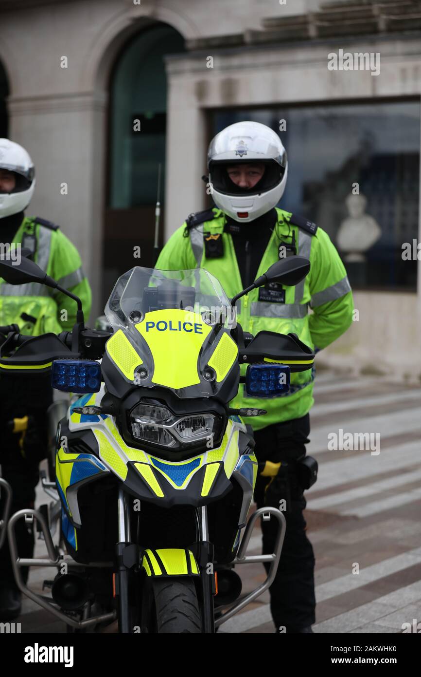 Police officers stand behind the new motorbikes that have been ...