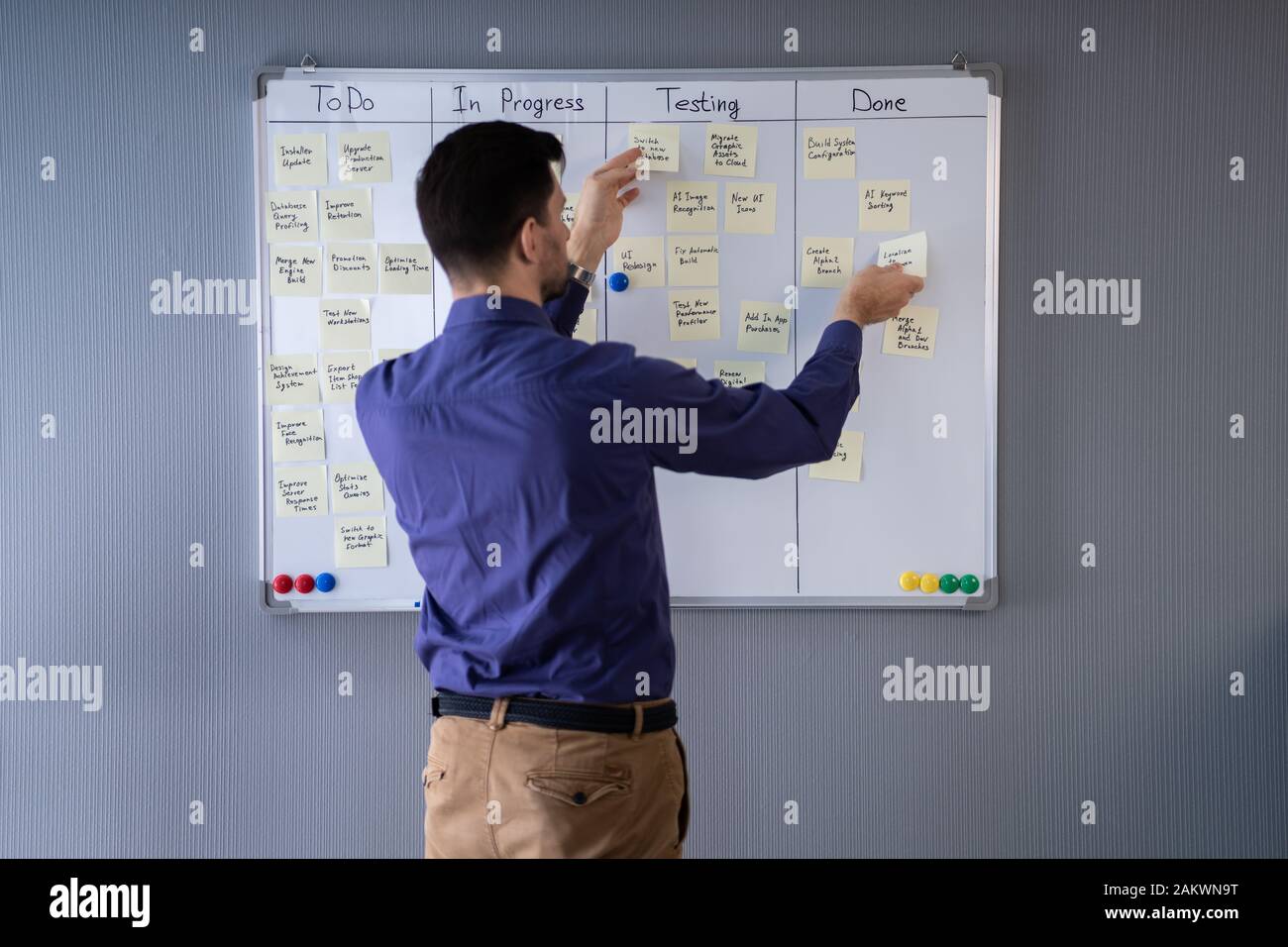 Side View Of Businessman Writing On Sticky Notes Attached To White ...