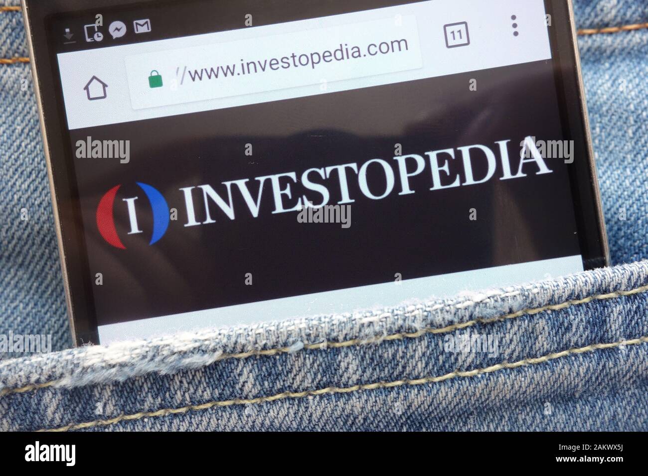 Investopedia website displayed on smartphone hidden in jeans pocket ...