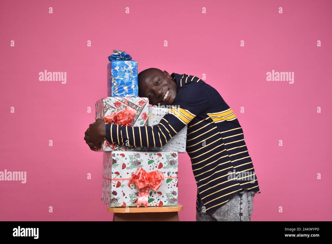 excited young black man feeling excited hugging a stack of gift boxes ...