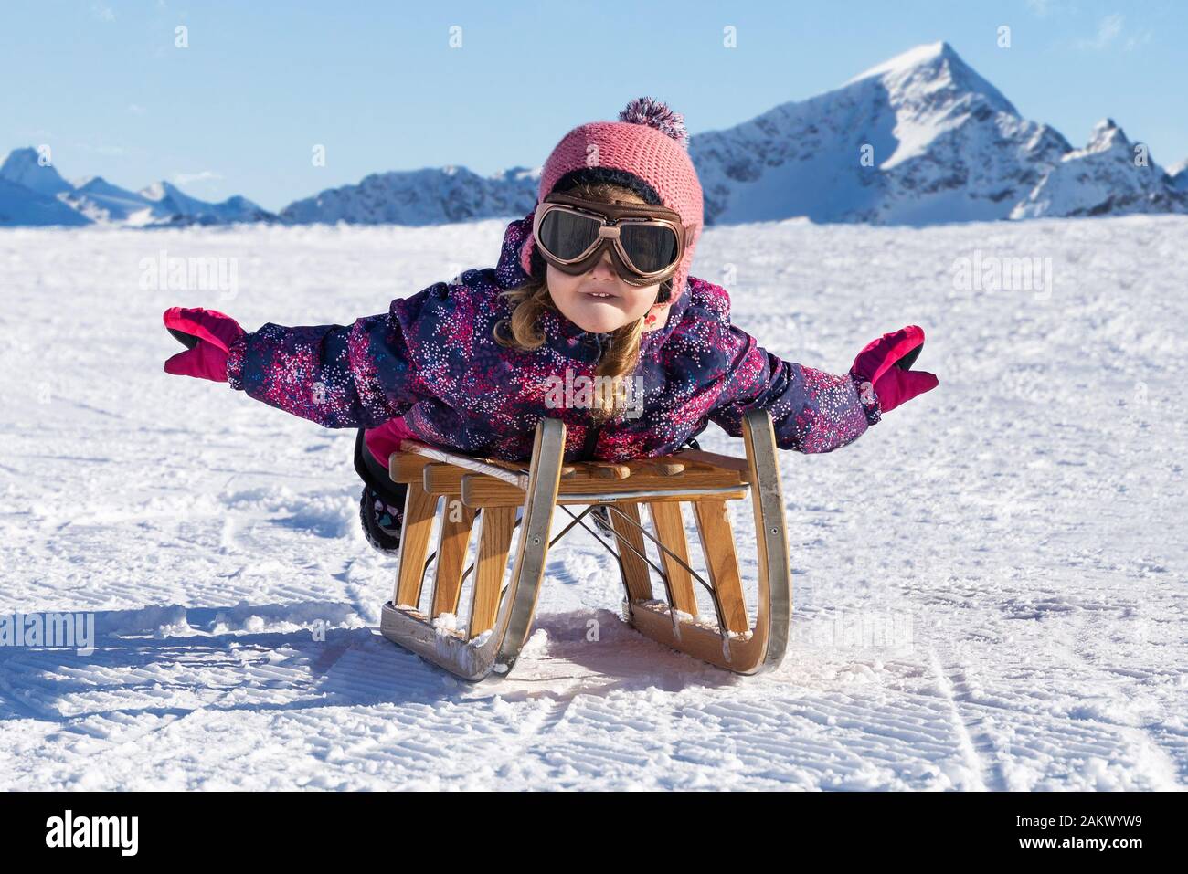 Cheerful Little Girl Sliding With Sledge In The Snow At Laax Stock ...