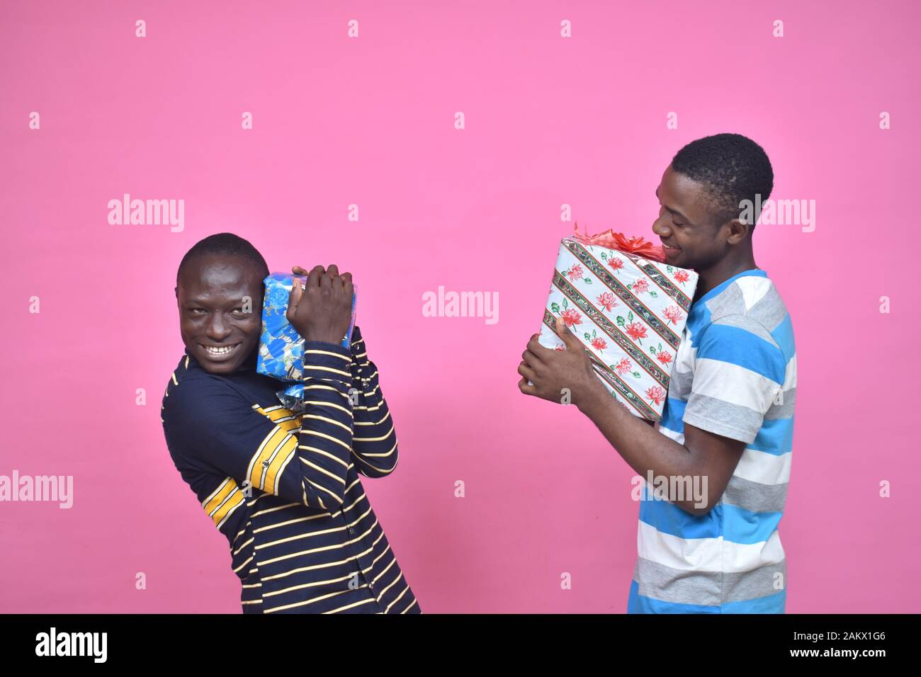 two young black men hugging gift boxes happily Stock Photo - Alamy