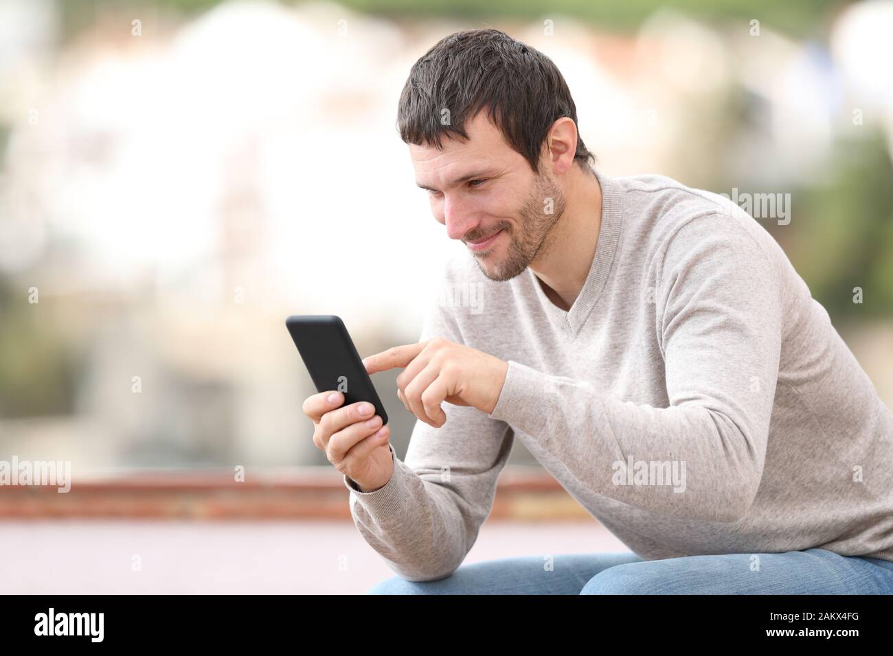 Man sitting on bench phone hi-res stock photography and images - Alamy