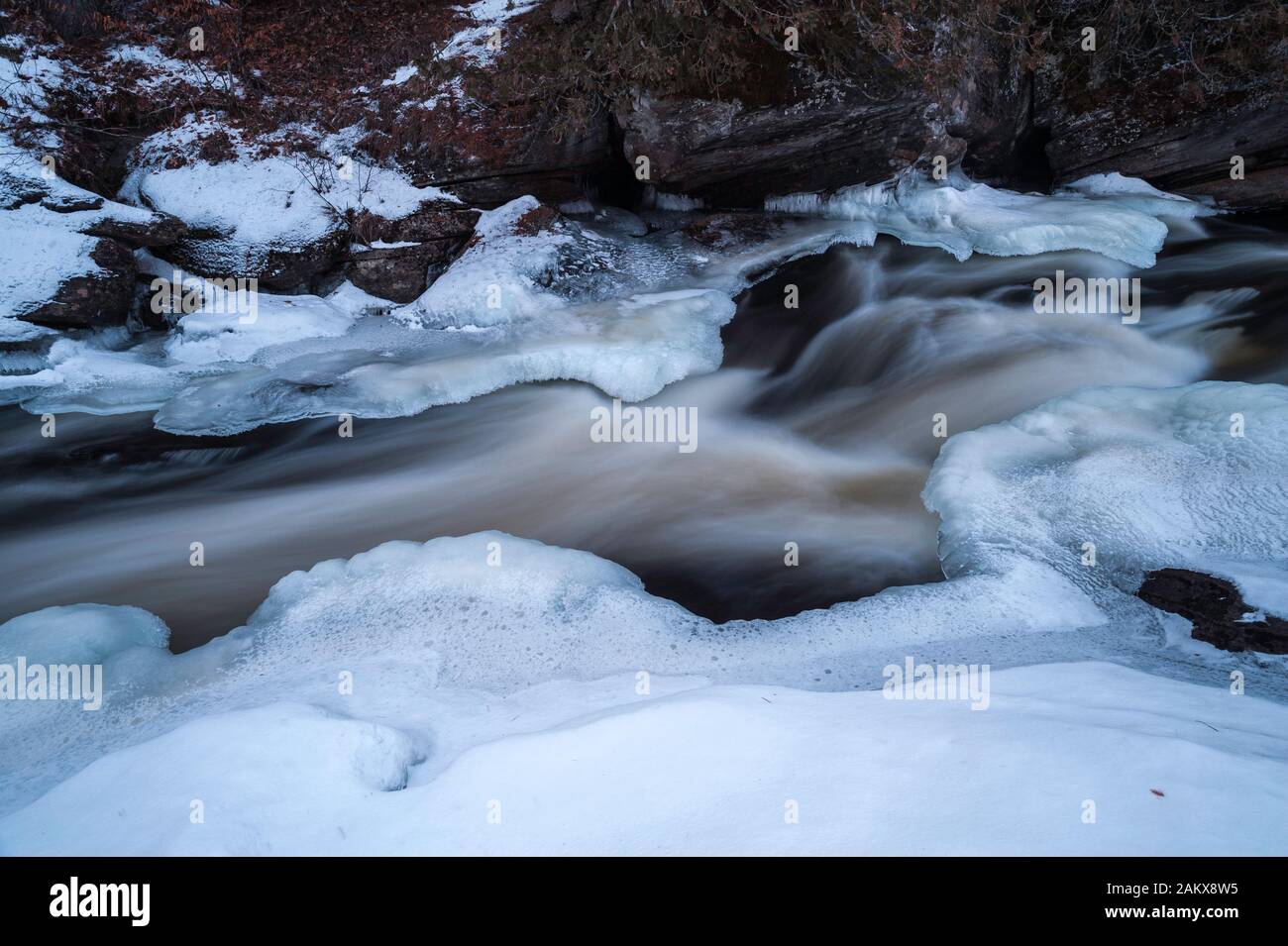 Winter water and flow of water through a winter landscape. Ice and snow ...