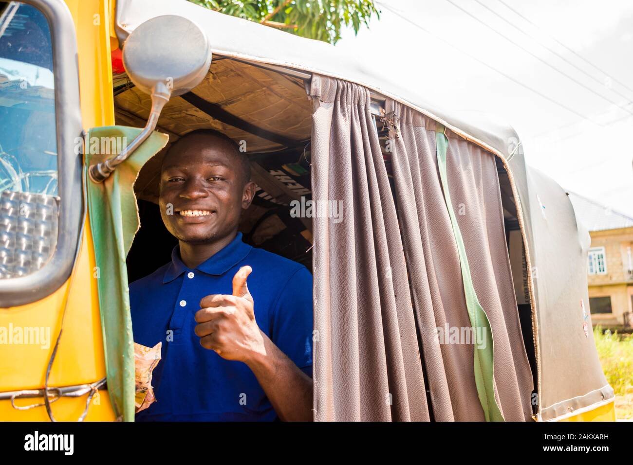 young african man driving a rickshaw taxi counting his money smiling ...