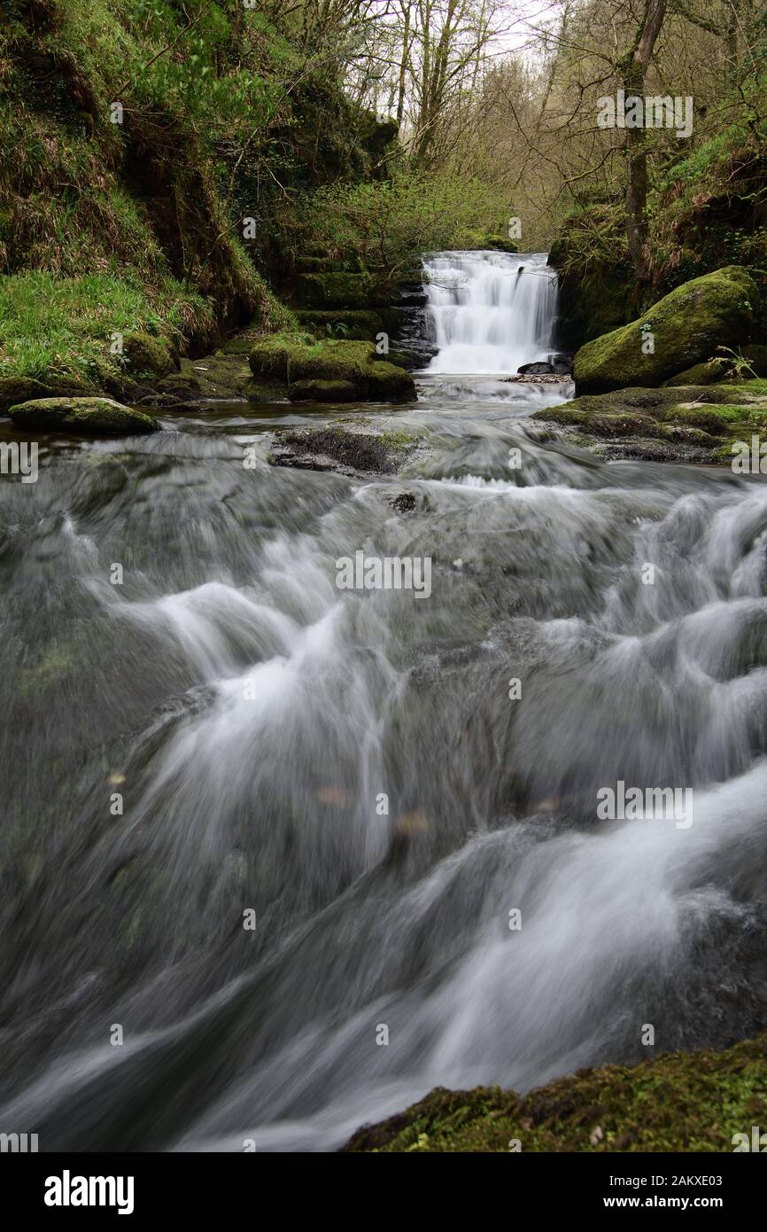 Long exposure of the big waterfall flowing through the woods at ...