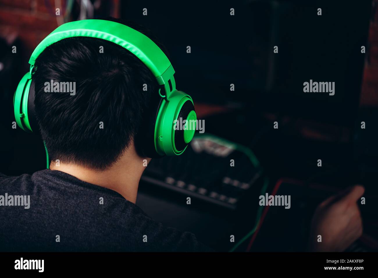 Back view of gamer in headphones playing video game Stock Photo - Alamy