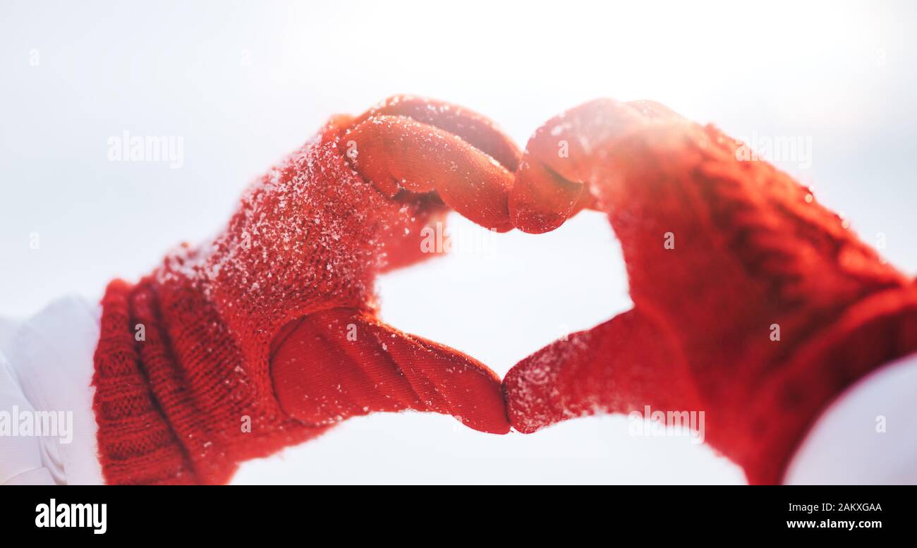 Woman making heart symbol with snowy hands Stock Photo - Alamy