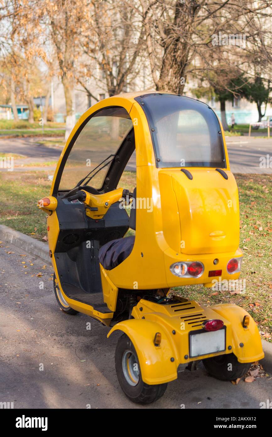 Yellow three wheeles motorcycles at parking. Back cabin view, nobody ...