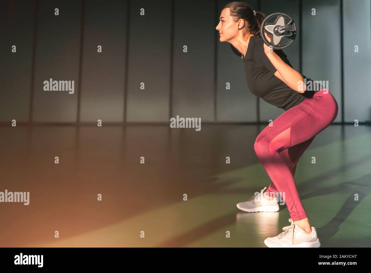 Strong woman weightlifting at the gym looking happy Stock Photo - Alamy