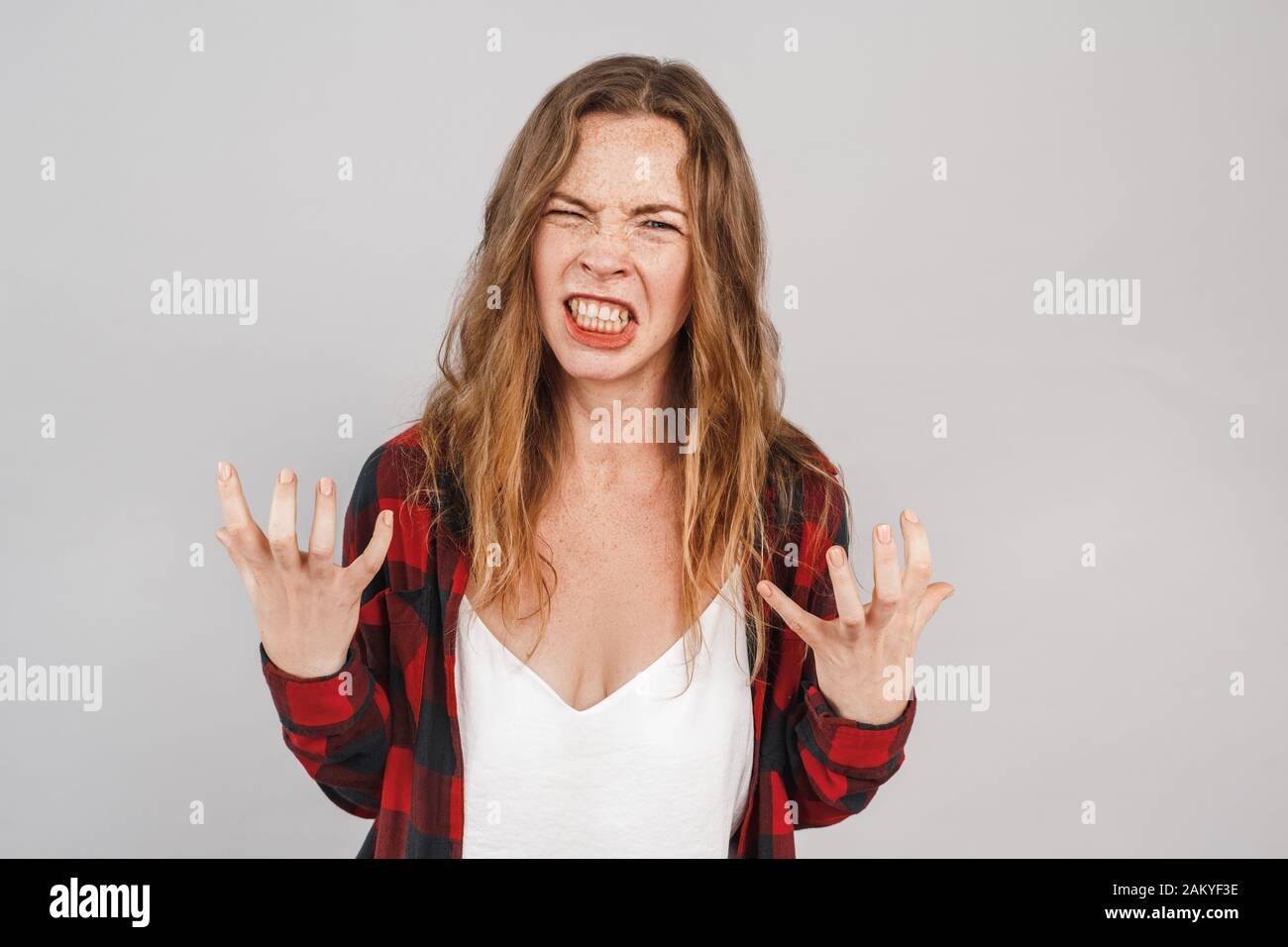 freestyle-young-woman-with-freckles-standing-isolated-on-grey