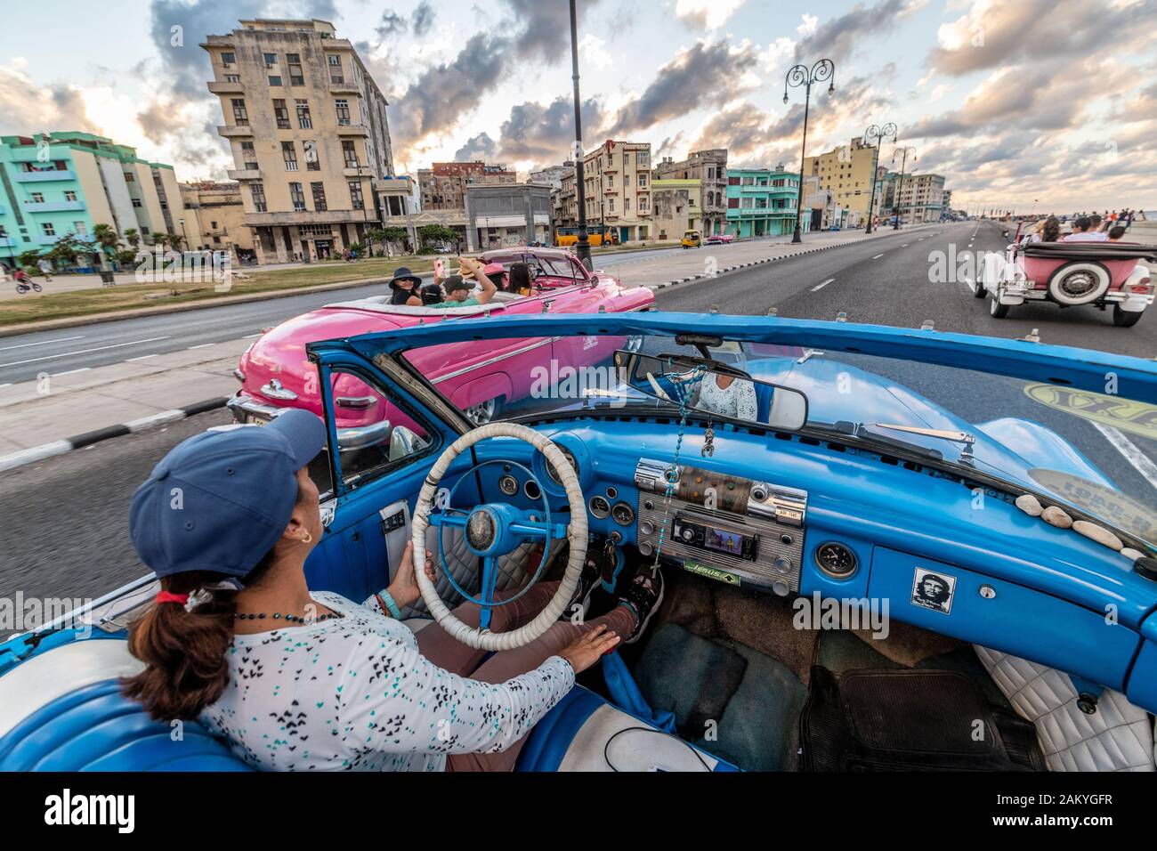 A classic blue American muscle car riding alongside some classic pink ...
