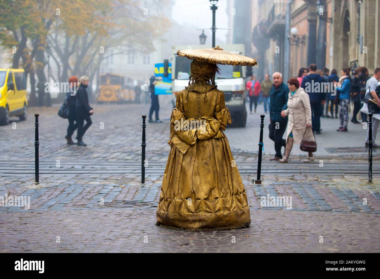 A female street performer, dressed in period costume and painted ...