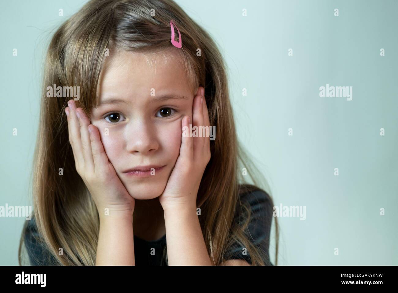 Close-up portrait of little child girl with long hair covering her ...