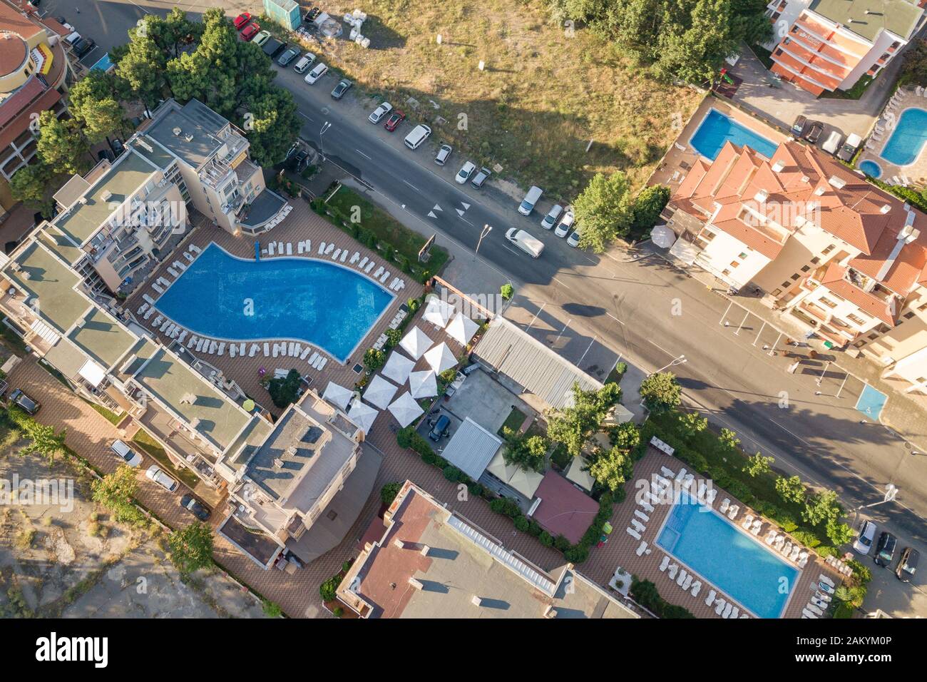 Top down aerial view of hotels roofs, streets with parked cars and ...
